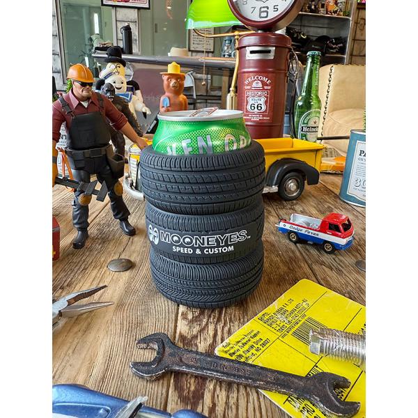 さすがムーンアイズ！このセンス ドストライクっす！タイヤを山積みしたガレージで目にする光景をそのまんまデザインにしたっていう缶クーラーです。柔らかめのゴム素材でできた本体は タイヤの質感そのまんまな感じでタイヤパターンもメチャクチャリアルな...