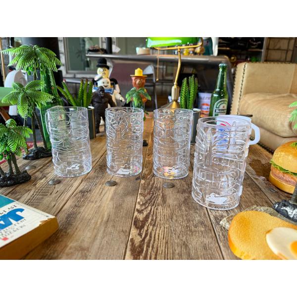最高ですね この雰囲気！カリフォルニアのビーチバーをそのまま切り取ったようなテーブルの上に並ぶのはプラスチック製ティキグラス4個セットです。軽くて割れないのにちゃんと「ガラス感」があるから チープじゃないの！しかも 光が当たると顔の彫りがキ...