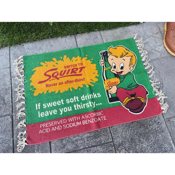 1950年代 アメリカのダイナーやガソリンスタンドに貼られていた「スクアート」の広告。そのノスタルジーをまるごと織り込んだようなコットンラグです。鮮やかなグリーンとレッドのコントラストにコミカルな坊や「バッドボーイ」のキャラクター。「If ...