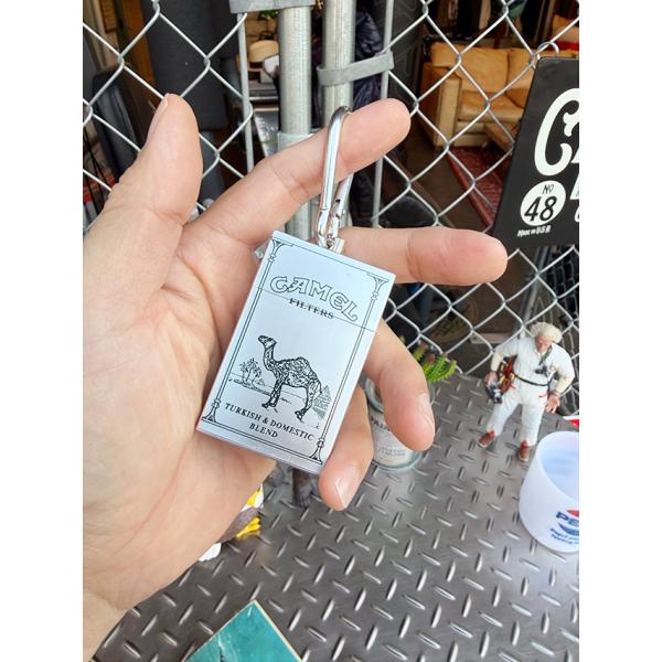 一見すると あの懐かしのタバコパッケージ。でも よく見ると中身は携帯灰皿なの！このギャップがたまらないキャメルデザインのメタル灰皿です。レトロなキャメルロゴにトレードマークのラクダがしっかりプリント。メタリックなボディが手のひらの中で光る昔...