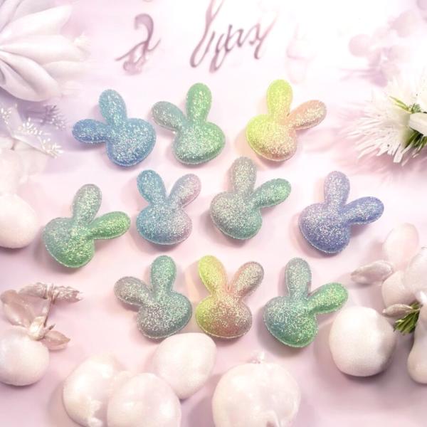 ウサギの形をしたクッションパーツです。グラデーションがきれいでキラキラしています。明るくて気分も華やかになりそうな色合いです。お子様のヘアゴムにしたり、持ち物にワンポイントで付けたりいろいろな用途でご使用ください。【内容数】カラーランダム ...