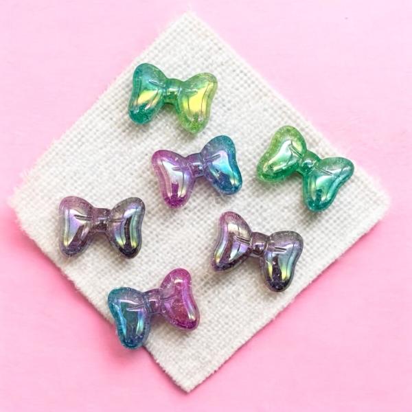 透明感のある美しいアクリル製のリボン型パーツです。幻想的なグラデーションカラーが光に当たってキラキラと輝き、作品に上品な華やかさをプラスしてくれます。おすすめポイント 透明感のある美しいグラデーションカラー 光の角度によって表情が変わる魅力...