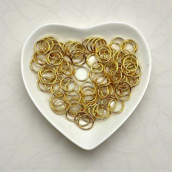 使いやすい12mmサイズ！スチール製ゴールドカラーの丸カン100個セットです。◆こんな用途に◆ハンドメイドアクセサリーの制作、バッグチャーム、キーホルダー制作、既製品の修理、DIYクラフトなど◆特徴◆・様々な用途に使える12mmサイズ・ネッ...