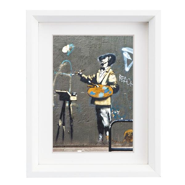 バンクシーのアートフレーム「ザ・ペインター（Sサイズ）」です。作家:バンクシー(詳細不明)英国を拠点とする身元不明の路上芸術家。世界各地のストリートや壁面・都市の橋梁等に、様々な政治的社会的テーマを訴える作品を数多く残している。2005年8...