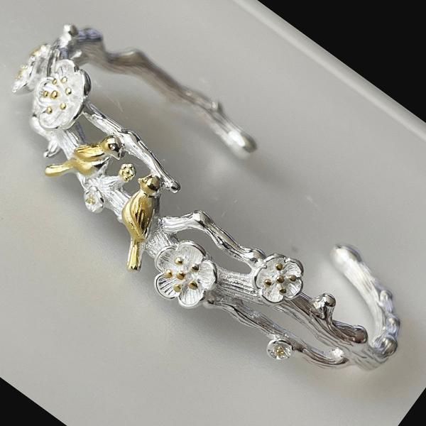 美しい桜の花をモチーフにしたシルバーのバングルゴールドの鳥が可愛いです【サイズ】フリーサイズ 円周：約17cm 、直径：約7cm、【素材】シルバー コーティング SilverPlated（925刻印あり）※Cリングのため調整は可能ですが、無...