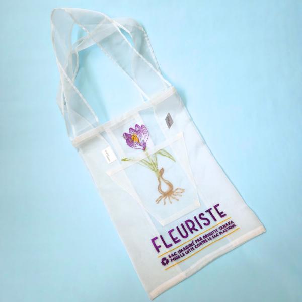 「FLEURISTE」の文字と、紫色のクロッカスの球根の刺繍の組み合わせがお洒落なブリジットタナカのお花屋さんバッグ。蜂の刺繍が施された内ポケット付き。サイズ:縦約39cm x 横約27.5cm x マチ約12cm、持ち手の高さ: 約26c...