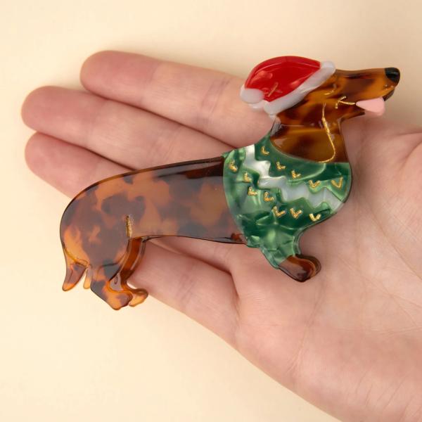 クリスマスの装いのダックスフントヘアクリップ。様々なアセテートを使用しており、商品ごとに色味が異なる場合がございます。クリップ部分の噛み合わせにおいて引っ掛かりがある場合がございます。サイズ: 約5.5cm × 9.3cm（多少の誤差がある...