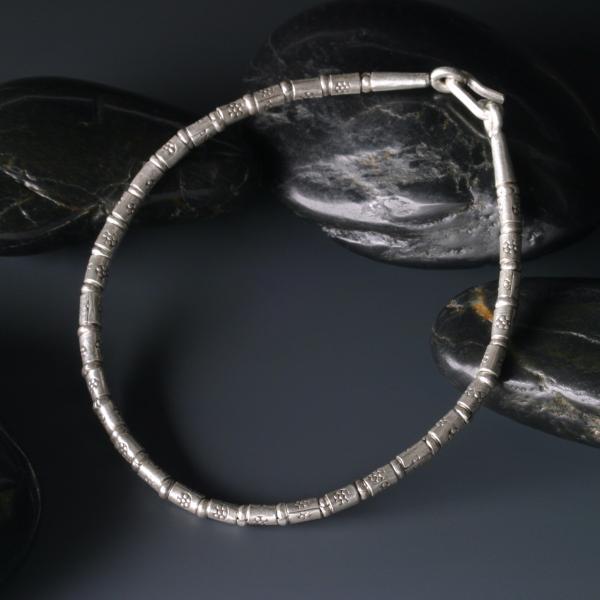 シンプルでオーソドックスな刻印のカレンシルバーを用いたシルバーブレスレットです。銀板を丸めて筒状にしたシルバービーズは見た目の太さに反して軽快な着け心地です。手作りの心地よさ、無駄のないシンプルさは手首と心に馴染み、長く付き合える一品になる...