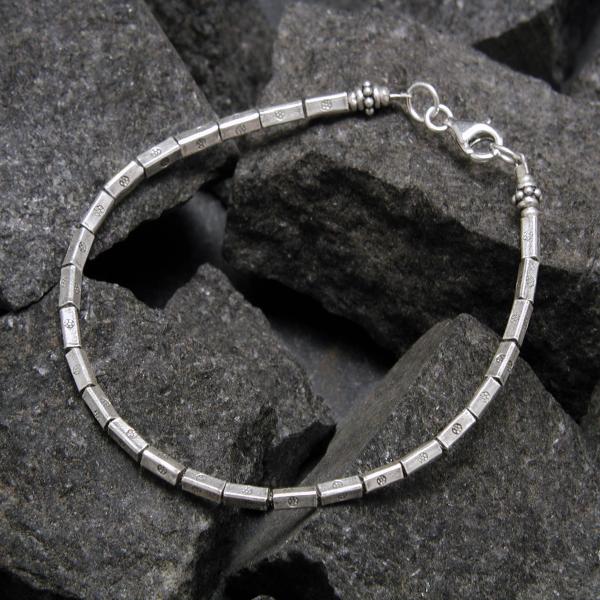 直方体で細身のカレンシルバーを連ねたシンプルでつつましいシルバーブレスレットです。シルバービーズはどことなく懐かしさを誘うアンティークのような質感で、気取らない手作り感が心地よいです。ひとすじの銀の光が手首をスッキリ見せます。軽量なので着け...