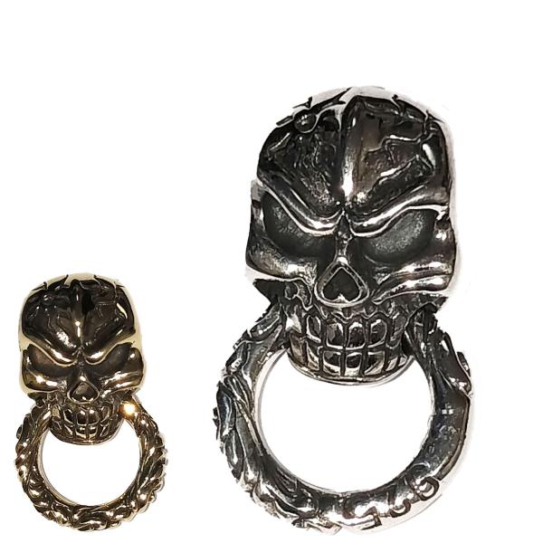 重厚なスカルデザインのドロップハンドル（トチカン）です。無機質になりがちな金具パーツに、立体感のあるスカルモチーフを採用することで、ウォレットに圧倒的な個性をプラスします。素材にはシルバー925と真鍮の2種類をご用意。使い込むほどに表情が変...