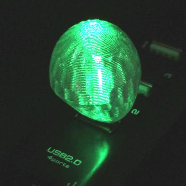 USB ポートにさしこんでつかう，ちいさなライトです．1 個の緑色 LED の光を 3D 印刷製で直径 2.4 cm のシェードがひろげます．パソコンのそばを照らしたり，電源アダプタとくみあわせてフットライトなどとしてつかえます．シェードに...