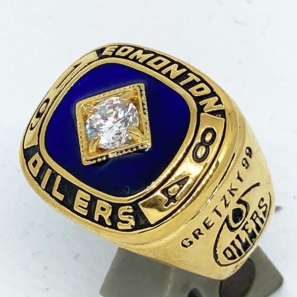 「Edmonton Oilers」1984年 チャンピオンリングです。リングサイズ：19号　(幅があるので1サイズ大きい物をおすすめします)重さ（約）：22ｇ最大幅（約）：24ｍｍ材質：ブラス製、金メッキ塗装　ジルコニア付き※金メッキは使用...