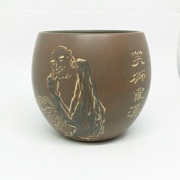 欽陶居工房　湯飲み  「笑獅羅漢」 十八羅漢杯十八羅漢の一人、伐闍羅弗多羅尊者、通称 笑獅羅漢です。ケガキは全て手彫りとなります。　分厚いためか重量感がありこの重さが好き！と言う方もおられます。鉄分を多く含む紫泥なのでとても固く頑丈でかつ、...