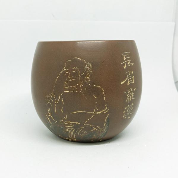 欽陶居工房　湯飲み  「長眉羅漢」 十八羅漢杯十八羅漢の一人、阿氏多尊者、通称 長眉羅漢です。ケガキは全て手彫りとなります。　分厚いためか重量感がありこの重さが好き！と言う方もおられます。鉄分を多く含む紫泥なのでとても固く頑丈でかつ、指では...