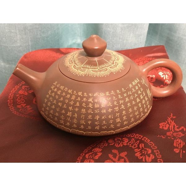 欽陶居工房　黄新作　急須　「心経」　蓮に囲まれた般若心経が心を落ち着かせてくれるような急須です。心経は全てハンドメイドの彫刻でこれほどの達筆を彫刻するのは至難の技ではないでしょうか？紫泥なのでとても固く頑丈でかつ、蓋を閉じた時の「キンッ」と...