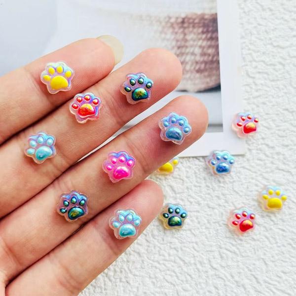 とても小さめサイズな猫の肉球パーツです！オーロラ加工がされているので、ちょっとキラキラするというか光沢があるような感じに仕上がっています。裏側は平面になっているので、基本的には貼り付けて使うパーツとなります。ネイルにも使えます！iPhone...