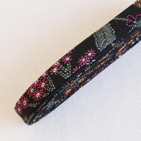 お洋服の裾上げやふちどり、小物の仕上げやリメイクに。デコレクションズオリジナル生地を使用した、コットン100％で柔らかい手触りの4つ折りバイアステープです。小さな花をつけた草花が点線で描かれた『スターチス』シリーズ。こちらは「ブラック」、黒...