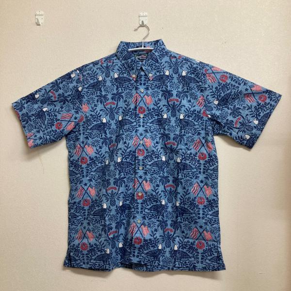 毎年の定番 アメリカ独立記念日アロハシャツ。定番生地のサラッと爽快なSpooner Kloth（スプーナークロス）にボタンダウン襟がシンボル的なデザインです。アメリカ国旗とハワイ州旗が小気味良いアクセントの絵柄は、とても涼しげで落ち着いたア...