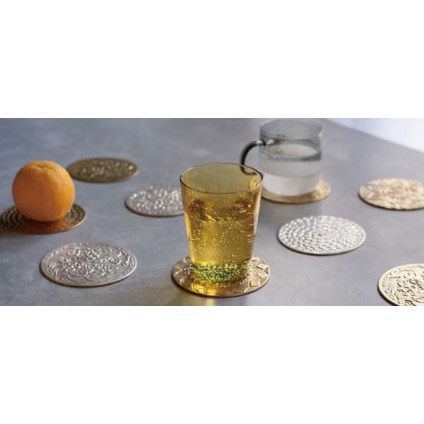 インドの職人により１枚ずつ手作業でプレス加工されている真鍮のコースター。インドらしい繊細な美しい模様が一つ一つ丁寧にプレスされており、 コースターとしてテーブルコーディネートの華やかなアクセントになる他、 オブジェやフラワーベースなどを乗せ...