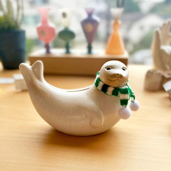 【マフラー付き限定モデル発売】フィンランド生まれのアザラシの貯金箱。フィンランドの銀行でノベルティグッズとして使われていたものを復刻しました。コロンとした丸いフォルムと何とも言えない表情がたまりません。※マフラー付きは限定モデルのため、再入...
