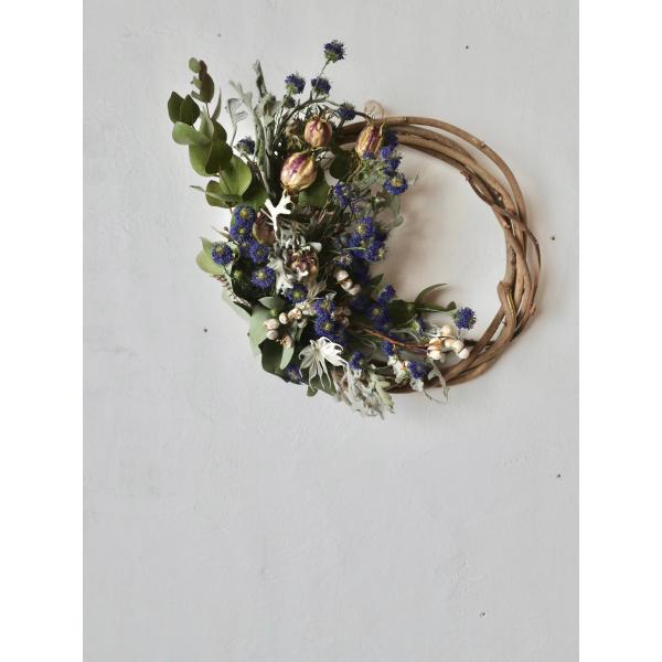ユーカリをベースに宿根アスターやシロタエギク、木の実など素朴な草花を合わせて仕立てたドライフラワーリースです。青い宿根アスターの花色とシルバーリーフ、ユーカリのグリーンが落ち着いたナチュラルな雰囲気を作ります。壁にかけて小さな草花の景色とし...