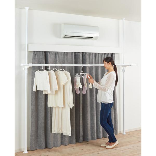 スイッチを押している間はポールが伸縮し、指を放すと止まる仕組み。最後にぐっと押し上げると、しっかり突っ張って固定されます。