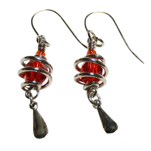 らせん型の立体ピアス赤色のビーズがかわいい。一番下には涙型のパーツが揺れてます。■全体の大きさ縦：26mm（丸カン部分から計測。ピアスの針の長さは含まず）横幅：6mm（最大幅）重さ：2,0g（左右一緒に1ペアーまとめて測量しました）銀色メッ...