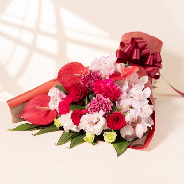 シンビジウム入りの豪華な大人色ブーケ高級感のあるシンビジウム、つやのある花姿が美しいアンスリウム、あでやかに咲き誇る赤いバラなど華麗な花々を贅沢に束ねた花束です。 それぞれの花の魅力を活かし、色合いのバランスを大切にしながら丁寧に束ねました...