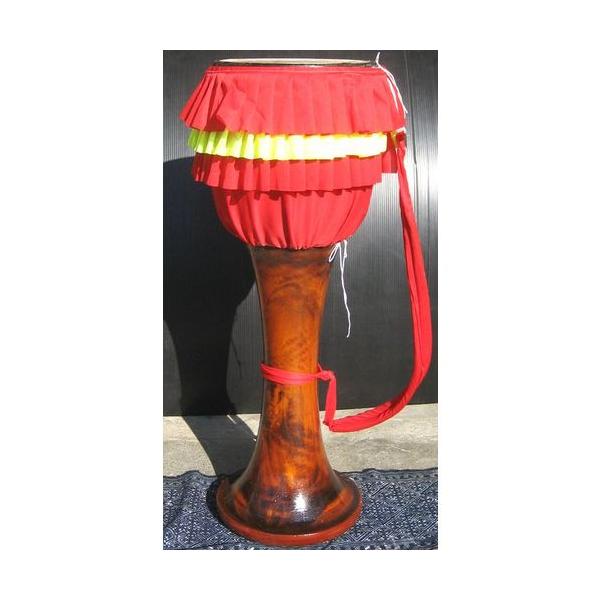 タイの背の高い片面太鼓です。片に掛けて腰の前にぶらさげて演奏することができ、タイの東北地方の祭りなどではなくてはならない存在です。打面にはヤギ皮が張られています。胴体:木製、ヘッド:ヤギ皮、装飾・片紐:綿布。サイズ-高さ:約82cm、打面直...