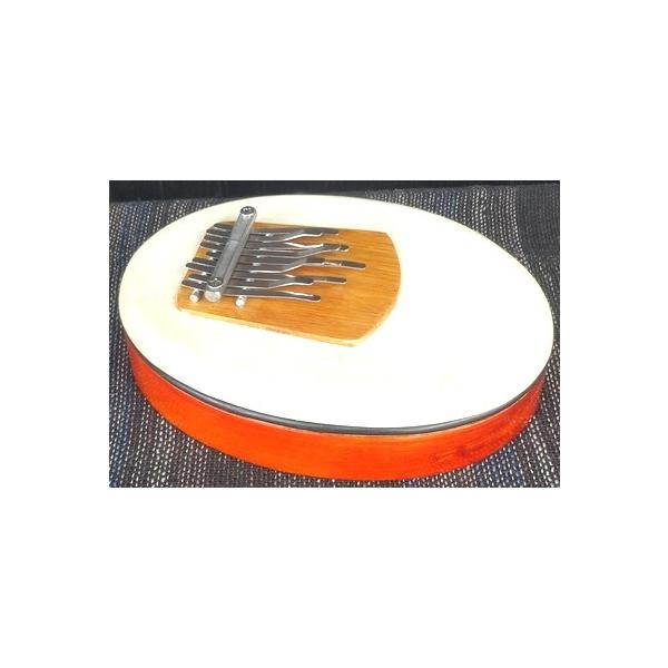 楕円形の木製胴体に牛皮を張った共鳴箱にステンレス製の弦を張った上質のカリンバです。<BR>９本の弦は正確に調律されており、質の良い音色が響きます。弦の振動が皮に伝わることによって音も大きく増幅されます。土台の裏には板が張られてお...