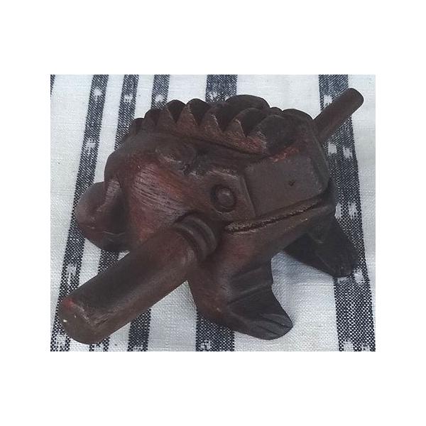 タイで作られている木製のカエルの楽器（？）です。付属の棒で背中をこするとカエルの鳴き声のような素朴な音が出ます。全部で５つの大きさがあるシリーズで一番小さな商品です。サイズ−全長：約１０ｃｍ、高さ：約６.５ｃｍ。
