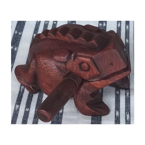 タイで作られている木製のカエルの楽器（？）です。付属の棒で背中をこするとカエルの鳴き声のような素朴な音が出ます。全部で５つの大きさがあるシリーズで３番目に大きな商品です。サイズ−全長：約１５ｃｍ、高さ：約８.５ｃｍ。