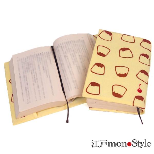 歌舞伎や舞踏の世界で愛用される梨園染めを用いた手ぬぐいブックカバーです。甘〜い香りがしてきそうなこっくりしたクリーム色の生地にたくさんのプリンをデザイン！手染めの生地は肌触りが良く、また薄くて乾きやすので使い勝手抜群です。優しい感触に癒され...