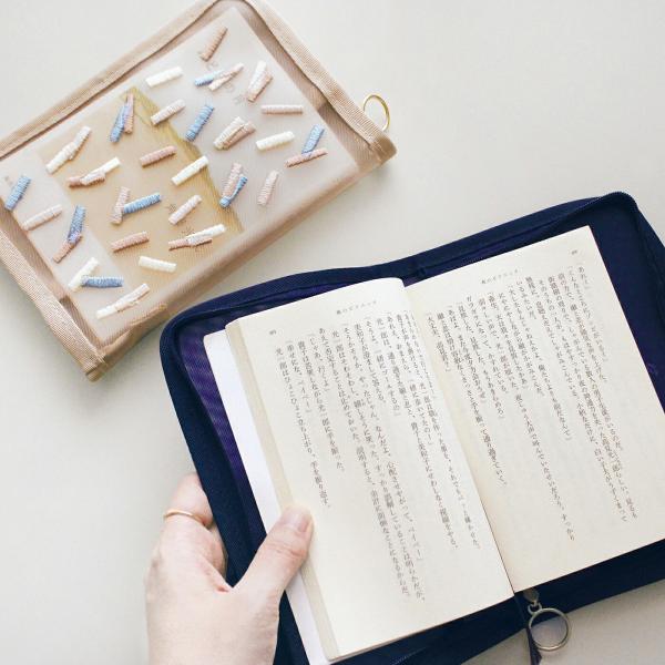 透け感のあるメッシュ生地に刺繍をあしらった文庫サイズのブックカバー。ラウンドファスナーなのでカバンの中でも本が開かないように持ち運ぶことができ、開けばそのまま本を読むことができます。軽やかな素材感とやさしい刺繍が、本の表紙をさりげなく彩り、...