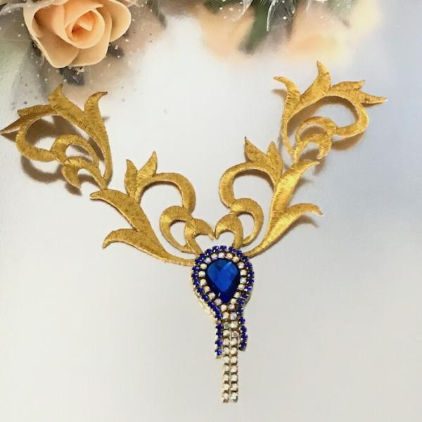 アイロン接着できるゴールドのタッセルのストーン付きネックライン形のワッペンモチーフになります。アクセントのセンターパーツはオリジナルデザインの雫模様のアレンジバージョンで、いろいろな衣装やドレスに合わせやすいのが魅力です。新体操、社交ダンス...