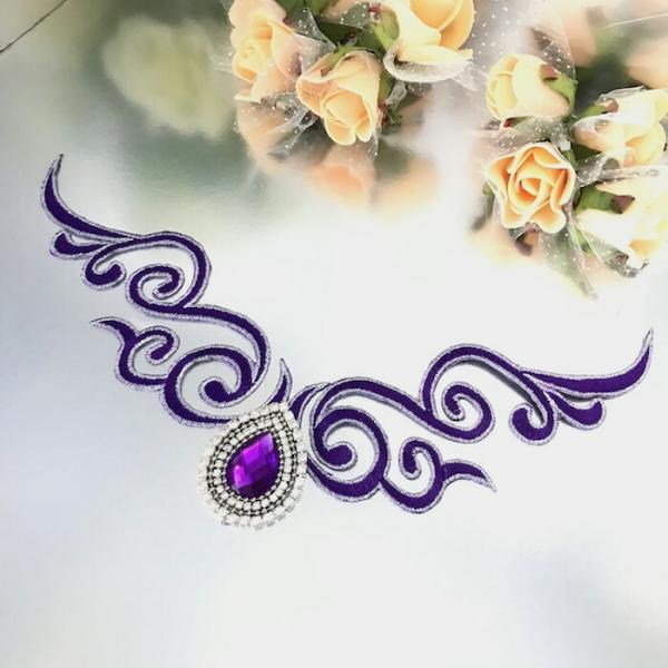 アイロン接着できるパープルのストーン付きネックライン形のワッペンモチーフになります。アクセントのセンターパーツは、雫形のオリジナルデザインで、いろいろな衣装やドレスに合わせやすいのが魅力です。新体操、社交ダンス、バトントワリング、レオタード...