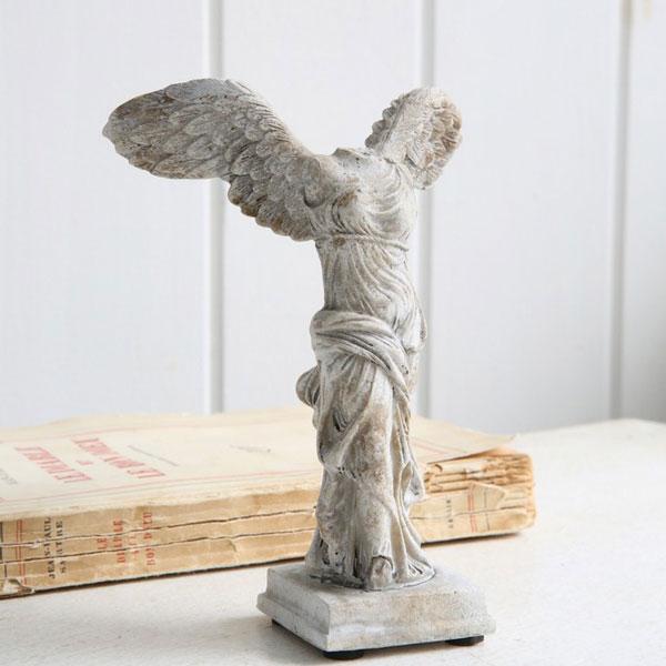 ルーヴル美術館所蔵「サモトラケのニケ像」をモチーフにしたオブジェ。翼を広げたシルエットが印象的で、洗練されたクラシックな佇まいが空間に静かな存在感を添えます。石調の質感と絶妙なエイジング加工により、インテリアに奥行きとストーリーをもたらしま...