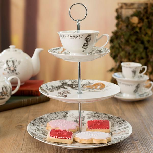 この楽しい3段ケーキスタンドでノスタルジックなワンダーランドへの旅に出かけましょう。どんな午後のティーセットにも個性的なアクセントとなるこのファインチャイナケーキスタンドには、アイコニックな引用「Have I gone mad?」と「Cur...