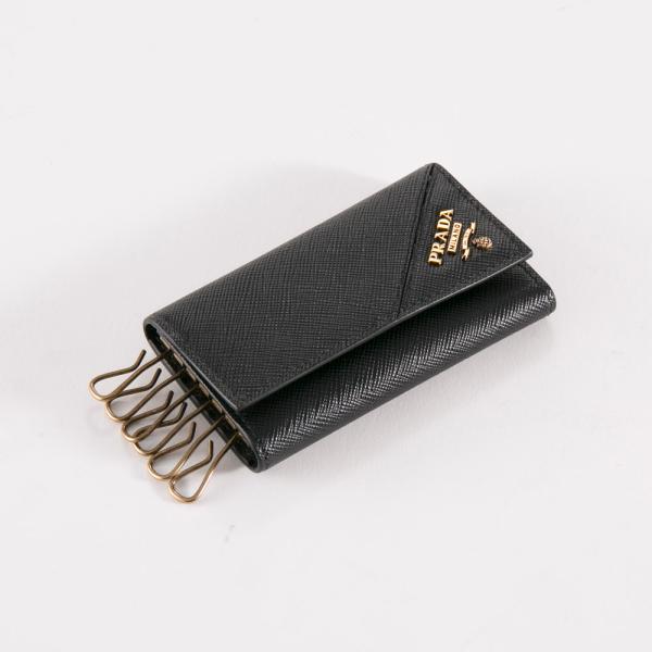 上質なレザーに高級感のあるメタルロゴをアクセントに効かせた一品。さっと開けやすいスナップ開閉や複数のキーリングを採用し、使いやすさを高めました。シンプルなデザインなので飽きが来ず、長くお使いいただけるのも魅力です。【プラダ/PRADA】【カ...