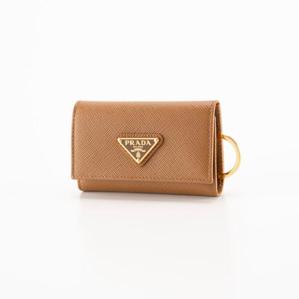 味のあるサフィアーノレザーのテクスチャーに、アイコニックな三角プレートが映えるキーケース。複数のキーフックとリングを備え、鍵をまとめて収納可能です。フラップはスナップボタンをダブルでセットし、中身をしっかりとカバーします。【プラダ/PRAD...