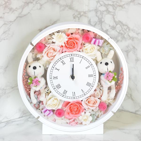 ■商品説明：愛らしい癒し系のラビットと優しい彩のお花でアレンジしました。時間を確認するときに、ほっと癒される花時計です。。■商品サイズ：高さ約24cm　幅約24cm　奥行約8.5cm■使用花材：プリザーブドフラワー(バラ、アジサイ、かすみ草...