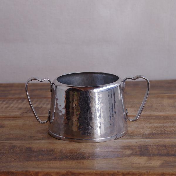 イギリスのステンレス食器メーカー Olde Hall のシュガーポットです。写真では一部 柄があるように見えてしまうものもあるのですが、全体がシルバー一色で、槌目が入っています。両側にハート型に見える持ち手がついており、クラシカルな雰囲気な...