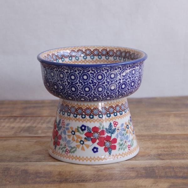 ポーランド陶器のペットボウルです。器に高い脚がついたデザインですが、重量感があり、安定しています。ブラウンやブルー、赤など、多色使いでレースのような模様や花柄がスタンプされた華やかなデザインです。ペット用のえさ台として作られたものですが、ア...