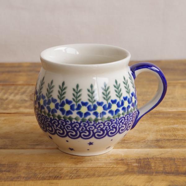 ポーランド食器のマグカップです。ブルーの花と、グリーンのリーフ柄が並び、カップの下部には小さな星の模様がスタンプされたかわいいデザインです。丈夫で割れにくく、オーブンでの使用も可能ですので、プリンや茶碗蒸しなどのお料理にもご利用可能で、保温...