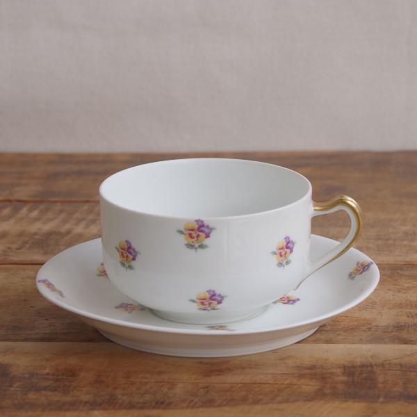 リモージュのティーカップ＆ソーサーです。パンジーの花が散らされたかわいいデザインです。カップの持ち手部分には、ゴールドが塗られています。シンプルなフォルムですが、かわいらしさもゴージャス感もあるデザインです。1900年前後のものと思われます...