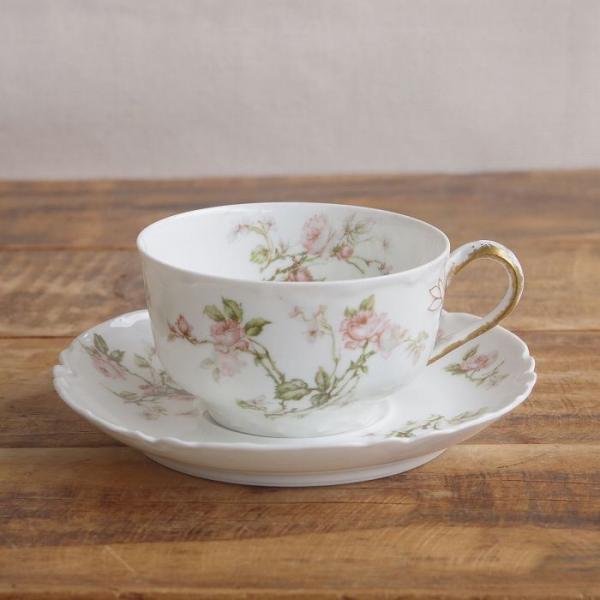 リモージュのティーカップ＆ソーサーです。Frontenac というシリーズのものです。リモージュらしい、非常に薄い陶磁器でできた繊細で軽いカップです。ピンクの花をつけた薔薇の枝がモチーフになっています。持ち手部分には、リボンのような形にゴー...