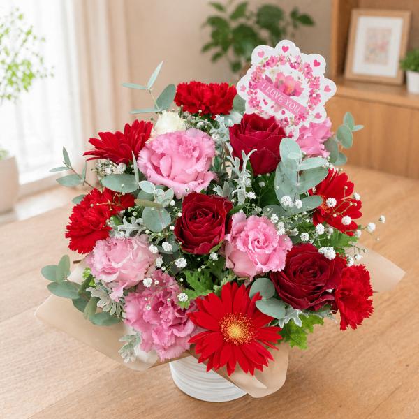 母の日の贈り物にぴったりな、華やかなワンサイドフラワーアレンジメントです。季節の新鮮なお花をたっぷり使い、当店のフローリストが一つひとつ心を込めてお作りします。正面から美しく見えるワンサイドスタイルなので、そのまま飾るだけでお部屋を華やかに...