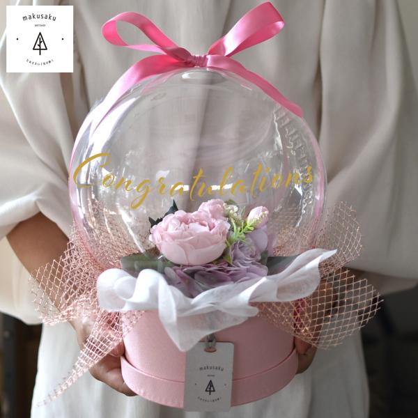 【商品名】バルーンフラワーbox(ピンク)【使用花材】アーティフィシャルフラワー　造花(バラ、アジサイなど)  ＊副材に関しましては入荷により変更があります。【商品特徴】クリアなバルーンのなかにアートフラワーで造られたミニブーケが入っていま...
