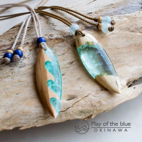 天然木とレジンを使ったネックレスです。ブルーカラーのレジンの奥行きのある美しい青みと、自然の風合いを感じる天然木が一体となった個性的なネックレスです。海やマリンスポーツ好きな方におすすめのサーフボードのようなシェイプが施されております。アク...