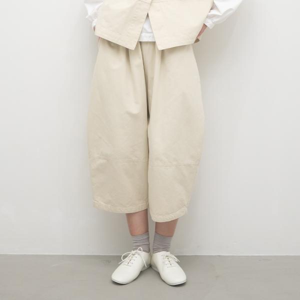 マットな質感のコットンライトドビークロスコクーンパンツ。程よく厚みがありながらほんのり柔らかさもあり、シルエットがきれいに表現される程よいハリ感のある生地です。ゆったりとした腰回りと深めの股上で履き心地よく、切替えを入れ立体的に仕上げたコク...